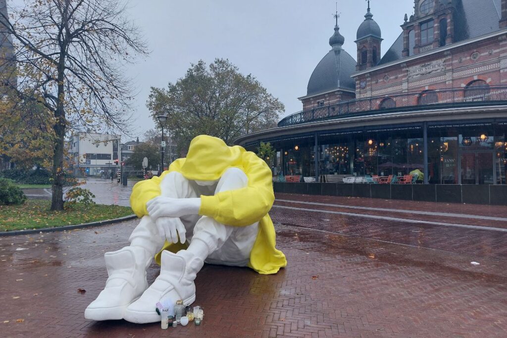 Dit doet dat grote beeld met gele jas op het Velperplein in Arnhem